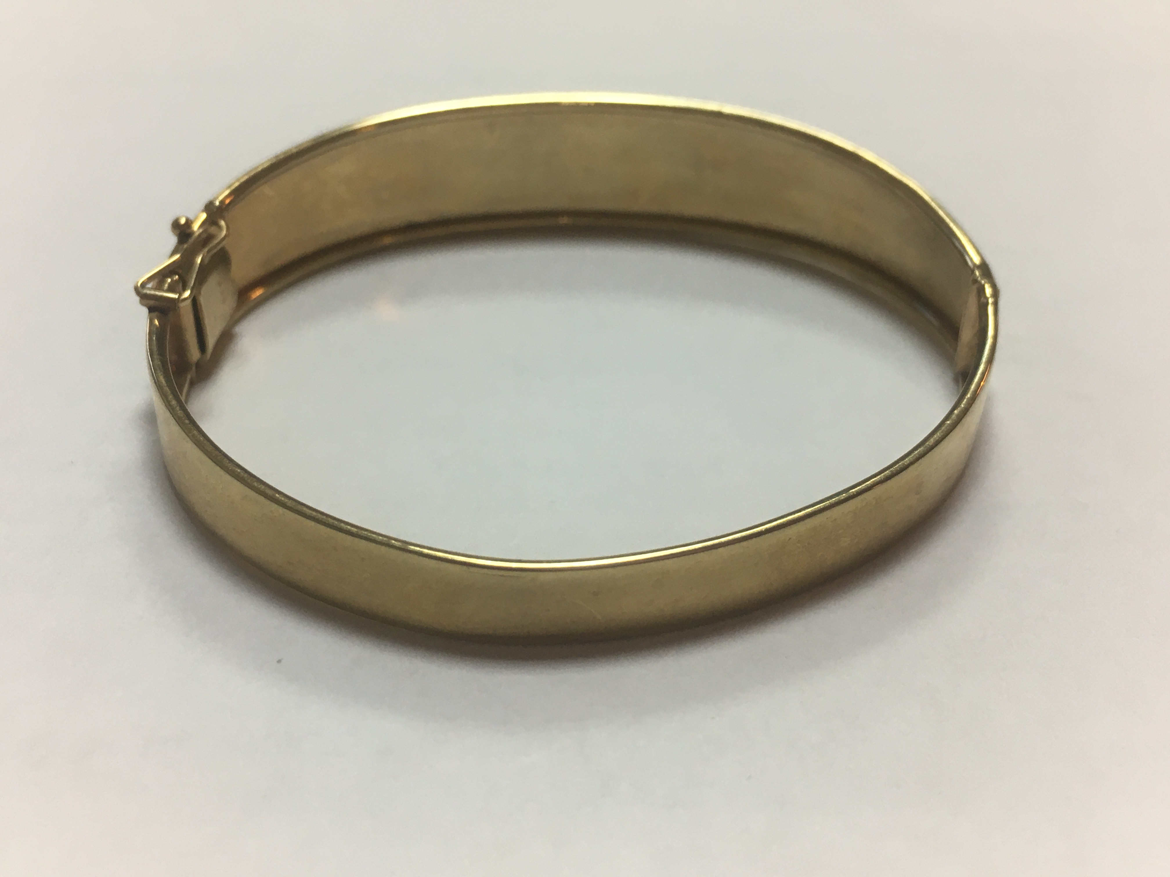Lot 46 - A 9ct gold hinged bangle,