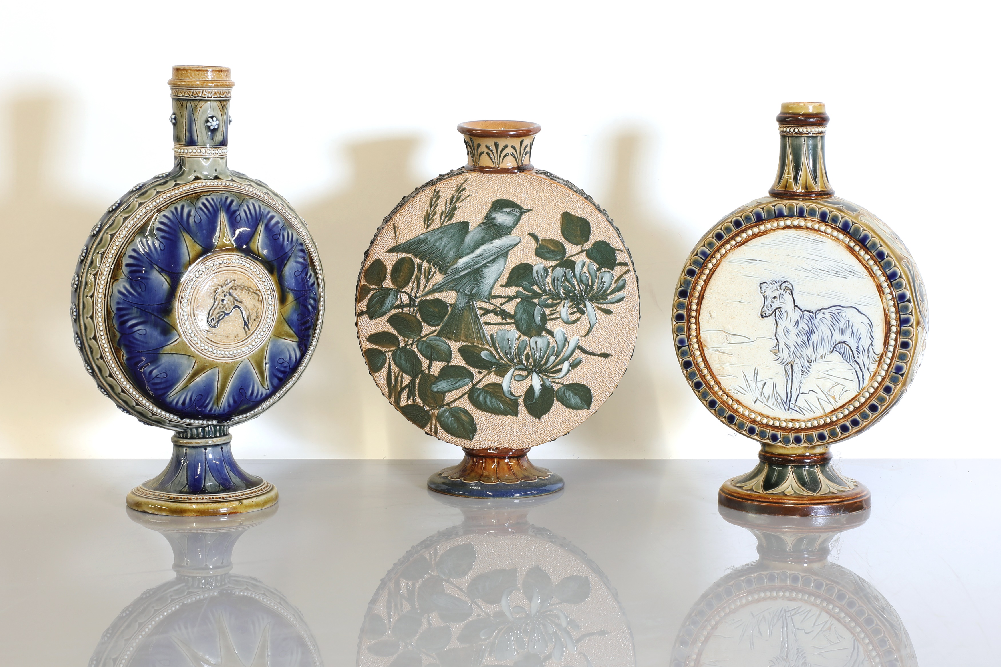 Lot 40 - Three Doulton Lambeth stoneware moon flasks,