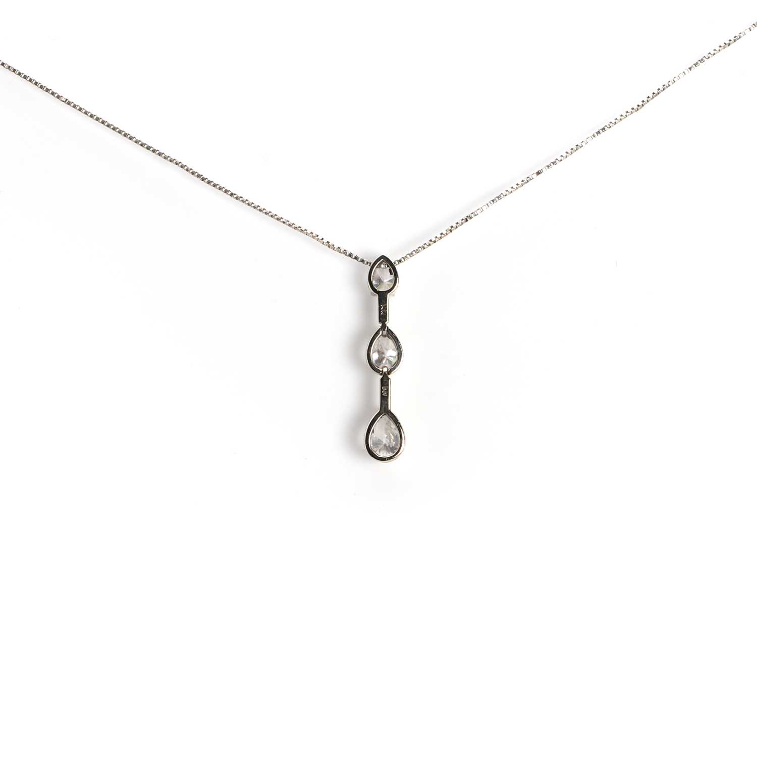 Lot 1075 - A three stone pear cut diamond pendant on