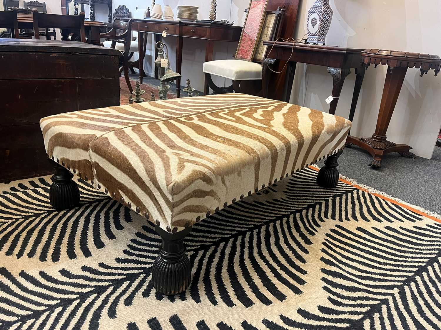 Lot 63 - A stained wood and zebra skin stool,