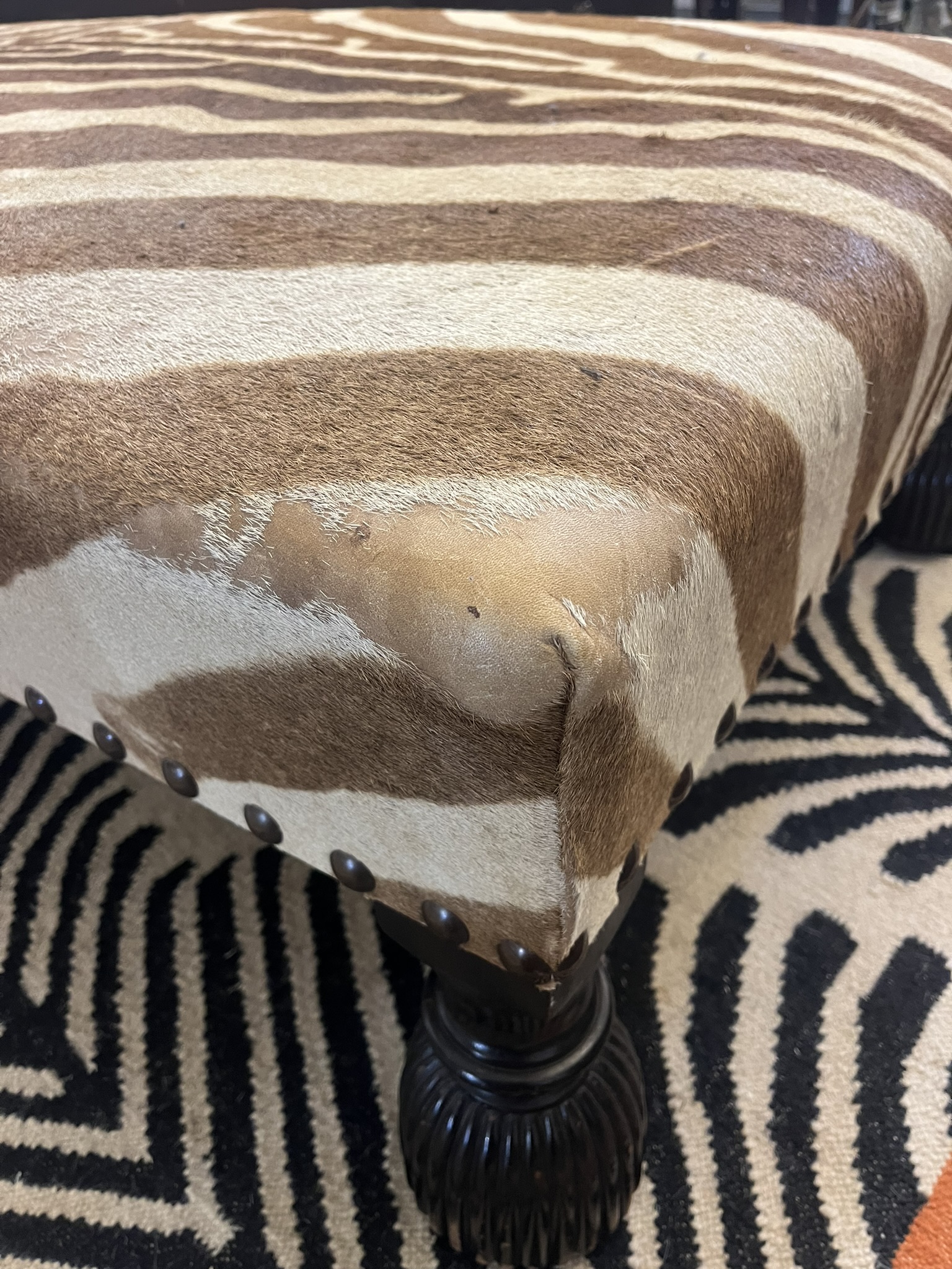 Lot 63 - A stained wood and zebra skin stool,