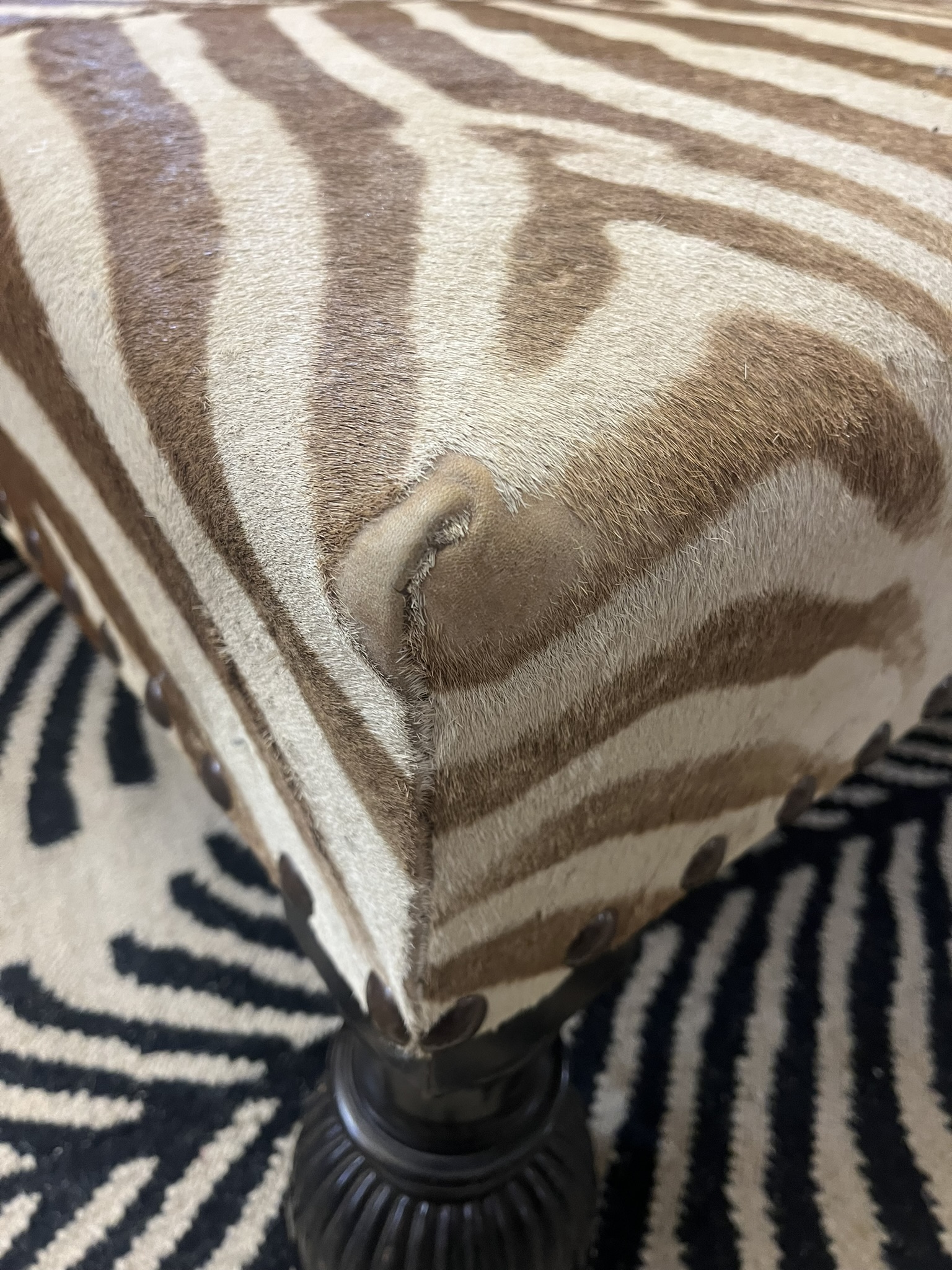 Lot 63 - A stained wood and zebra skin stool,
