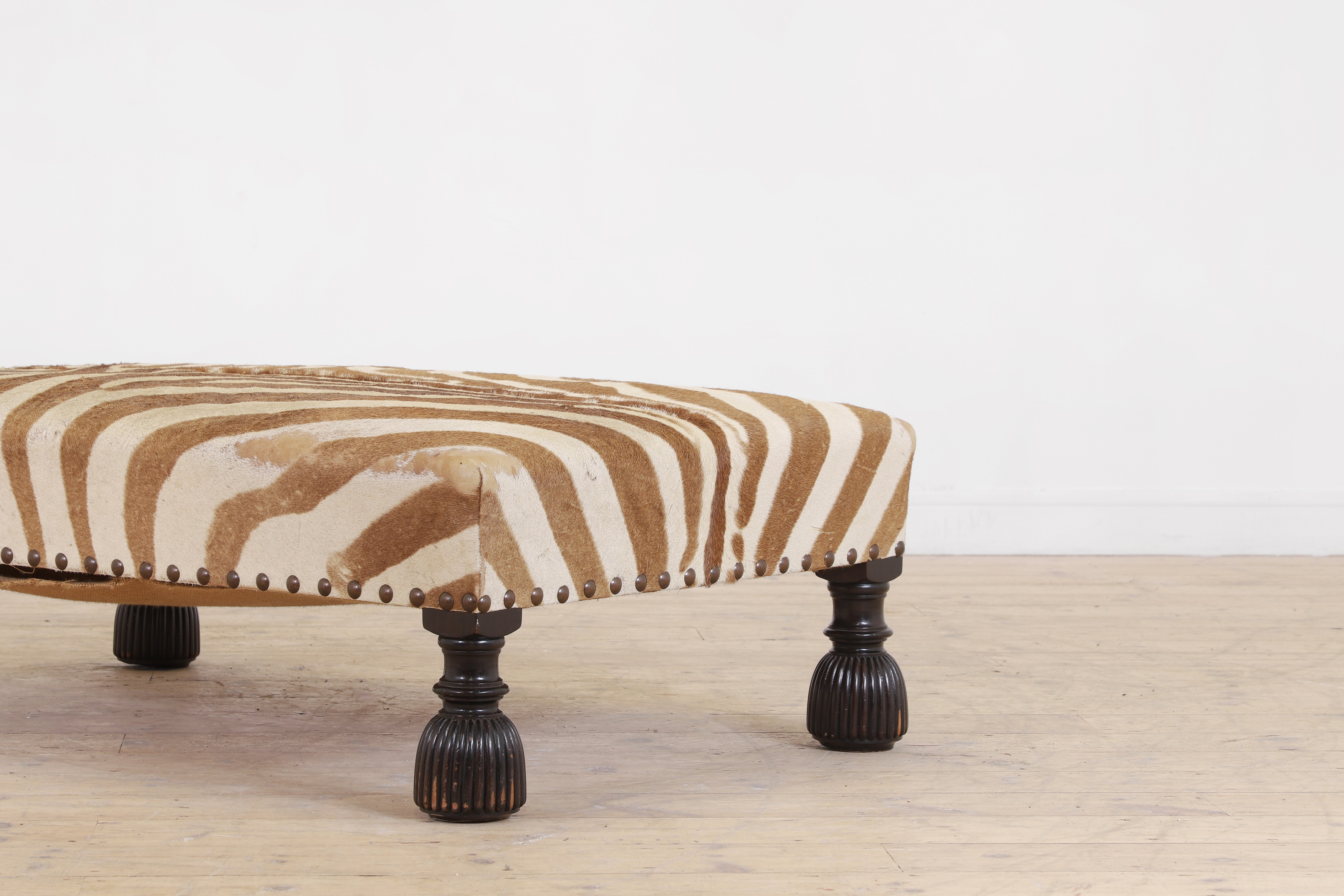 Lot 63 - A stained wood and zebra skin stool,