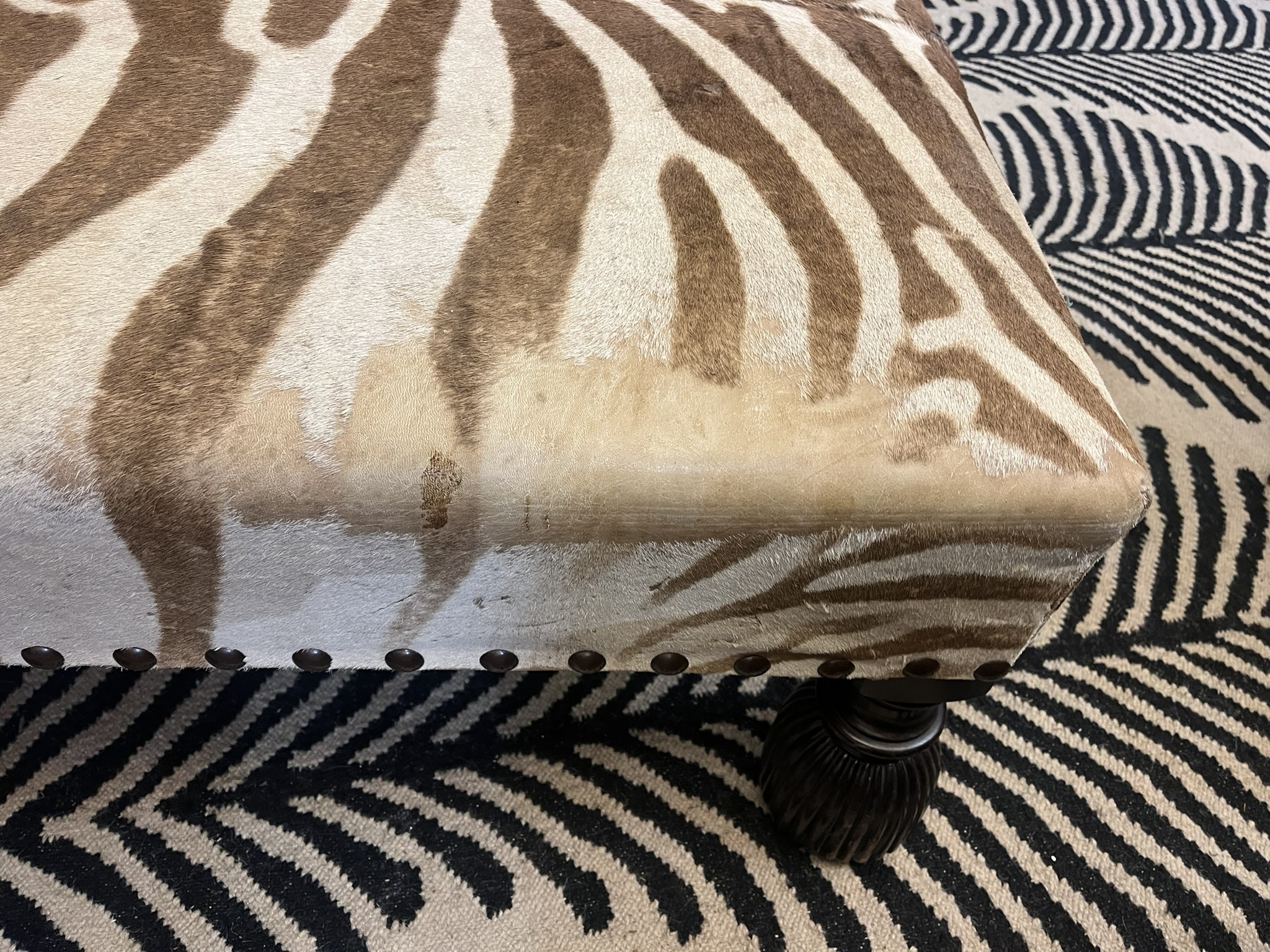 Lot 63 - A stained wood and zebra skin stool,