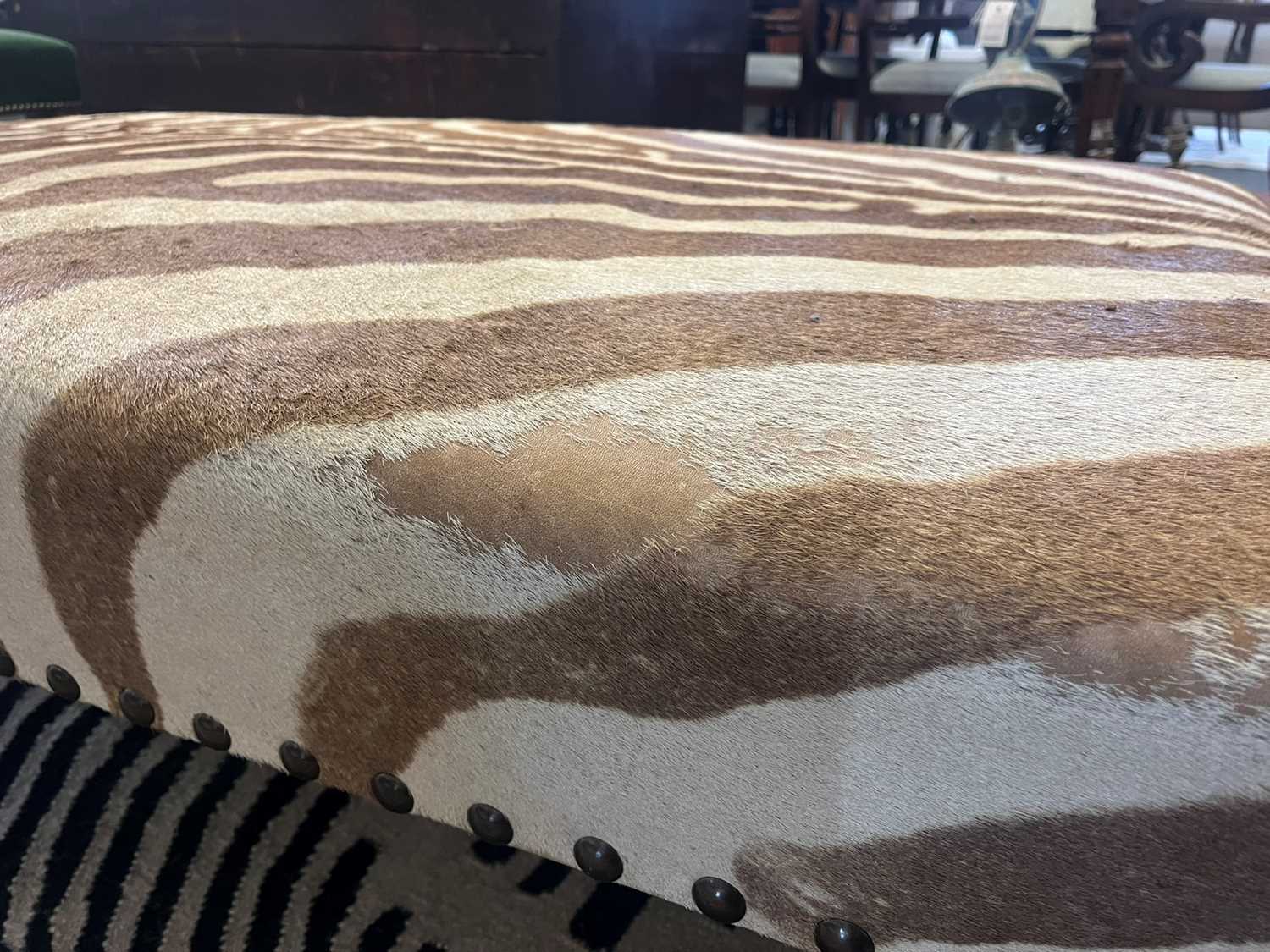 Lot 63 - A stained wood and zebra skin stool,