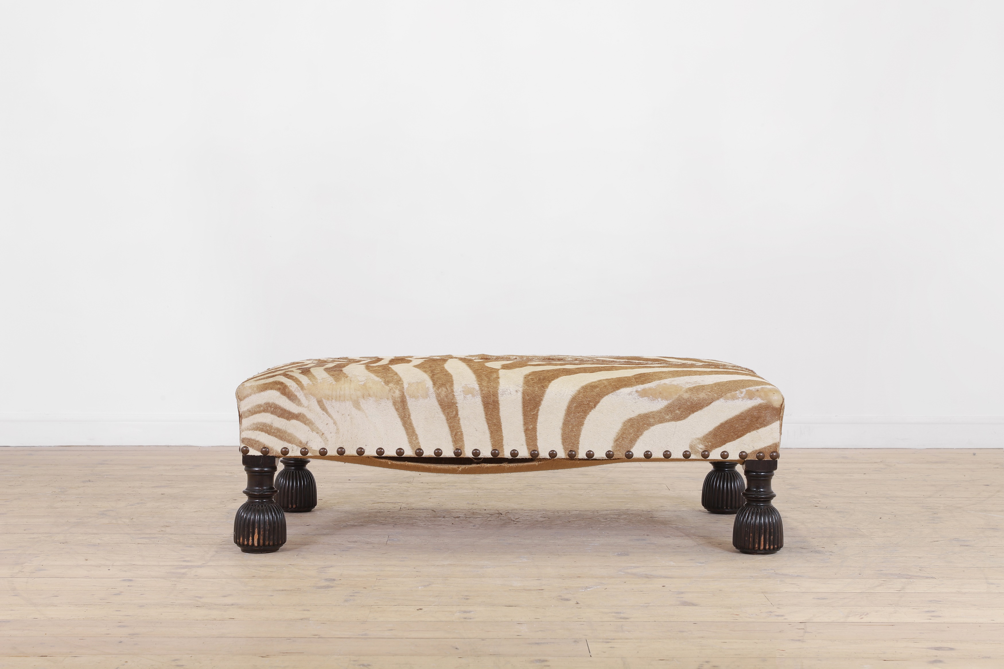 Lot 63 - A stained wood and zebra skin stool,