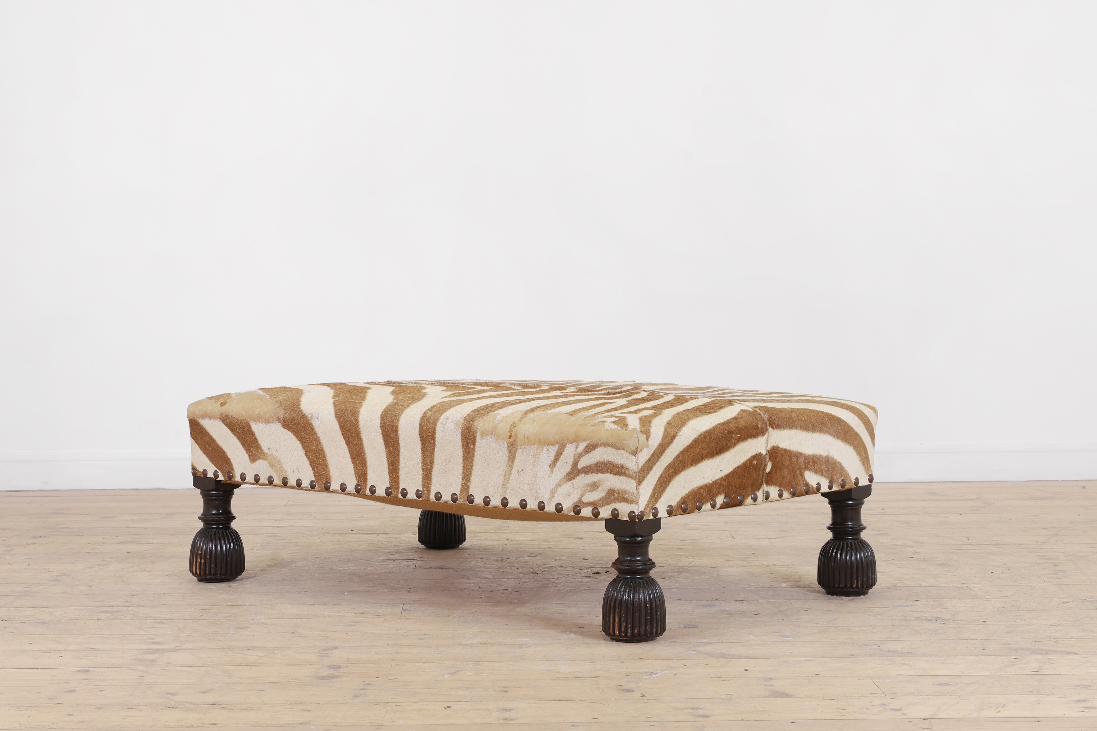 Lot 63 - A stained wood and zebra skin stool,