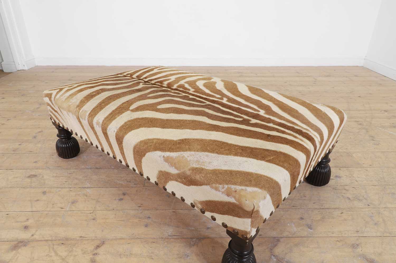 Lot 63 - A stained wood and zebra skin stool,