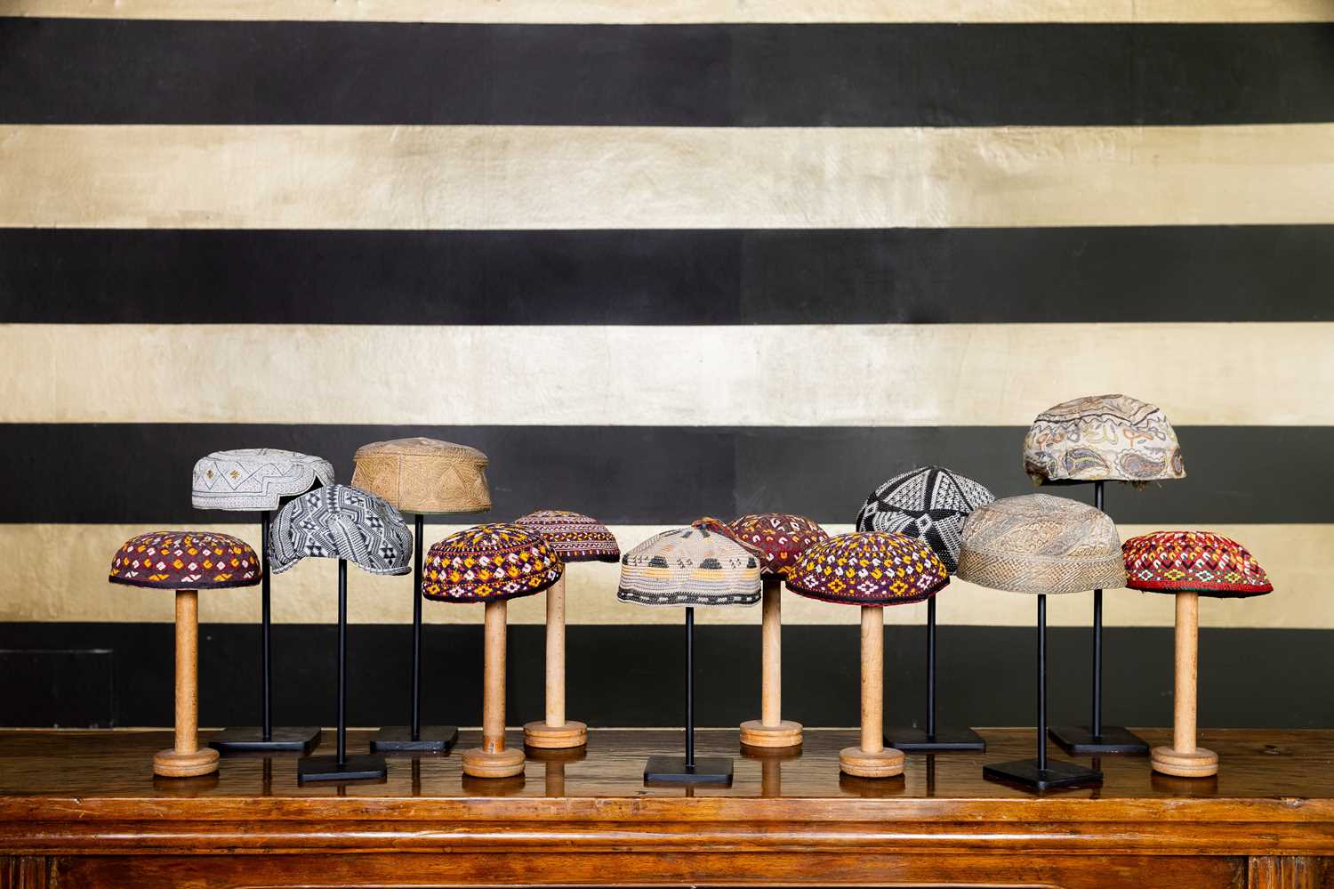 Lot 143 - Thirteen various embroidered caps on stands,