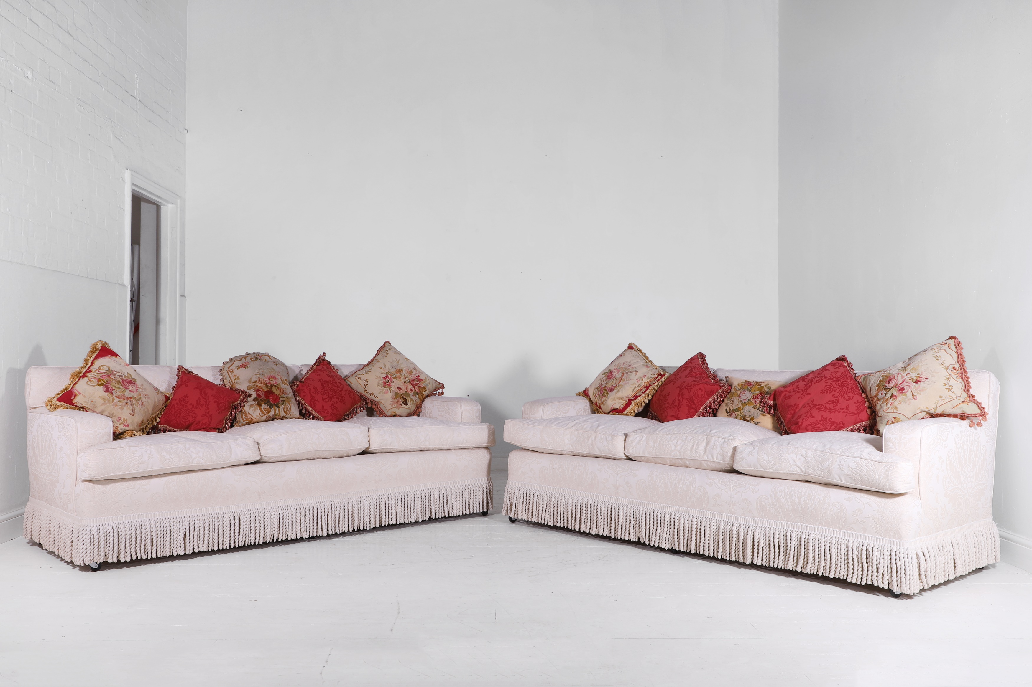 Lot 1 - A pair of upholstered three-seater sofas,